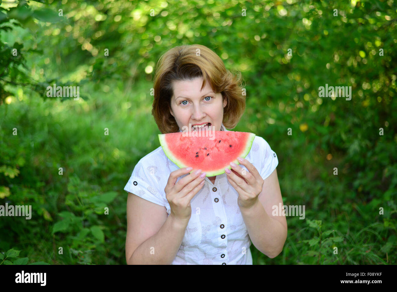 Woman with a slice of watermelon in nature Stock Photo - Alamy