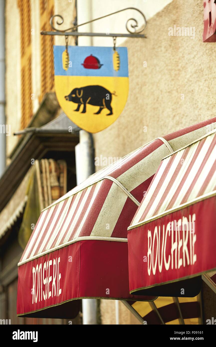 Shield shaped signboard with pig sign hanging outside French butcher ...