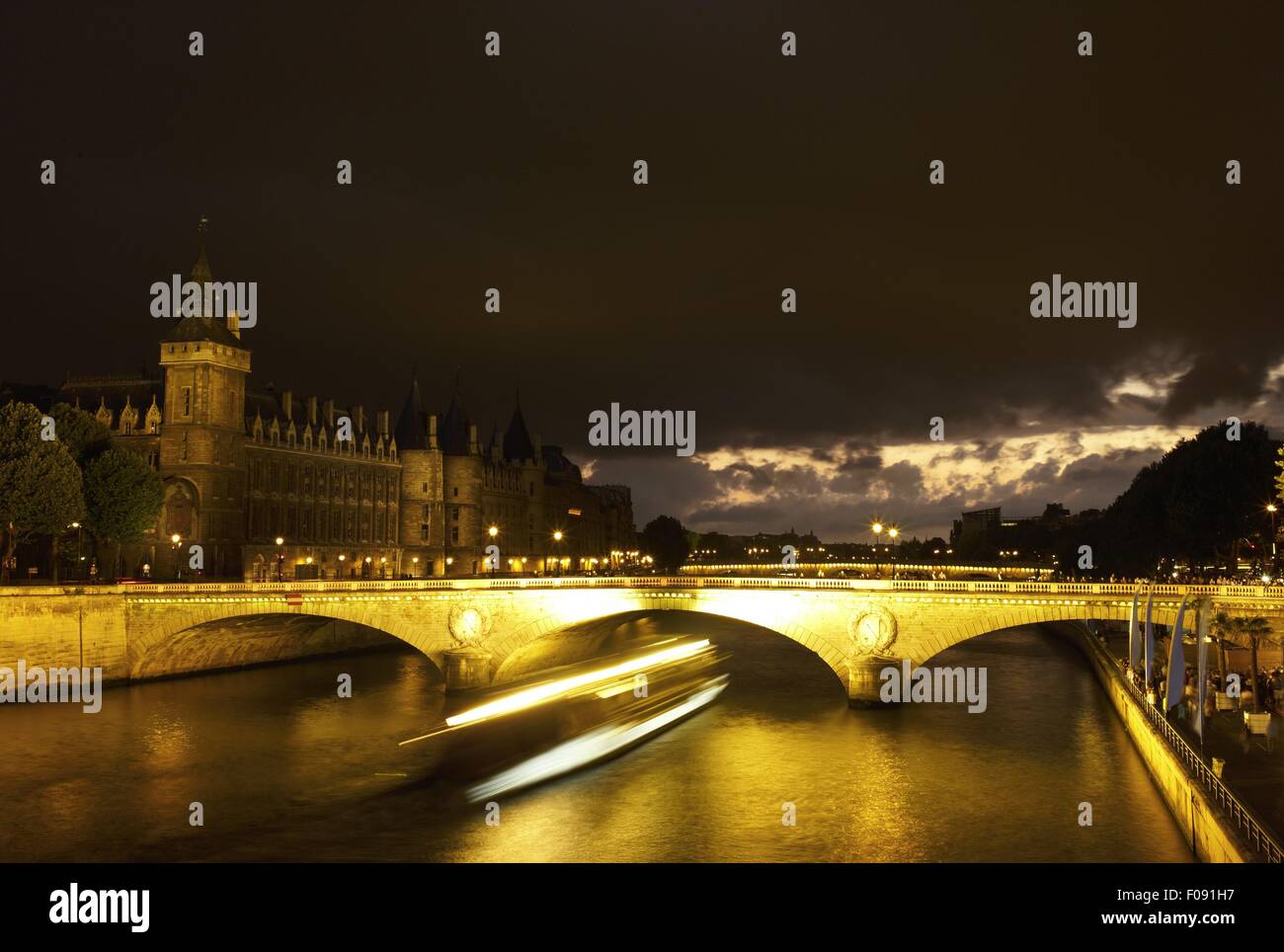 Illuminated Pont au Change bridge at evening in Paris, France Stock ...