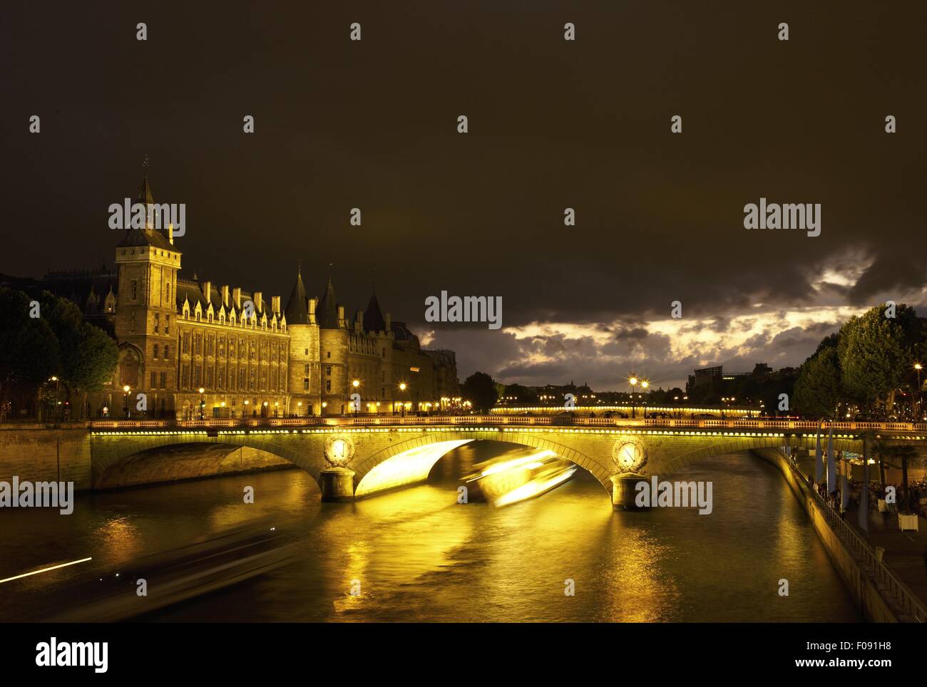 Illuminated Pont au Change bridge at evening in Paris, France Stock ...