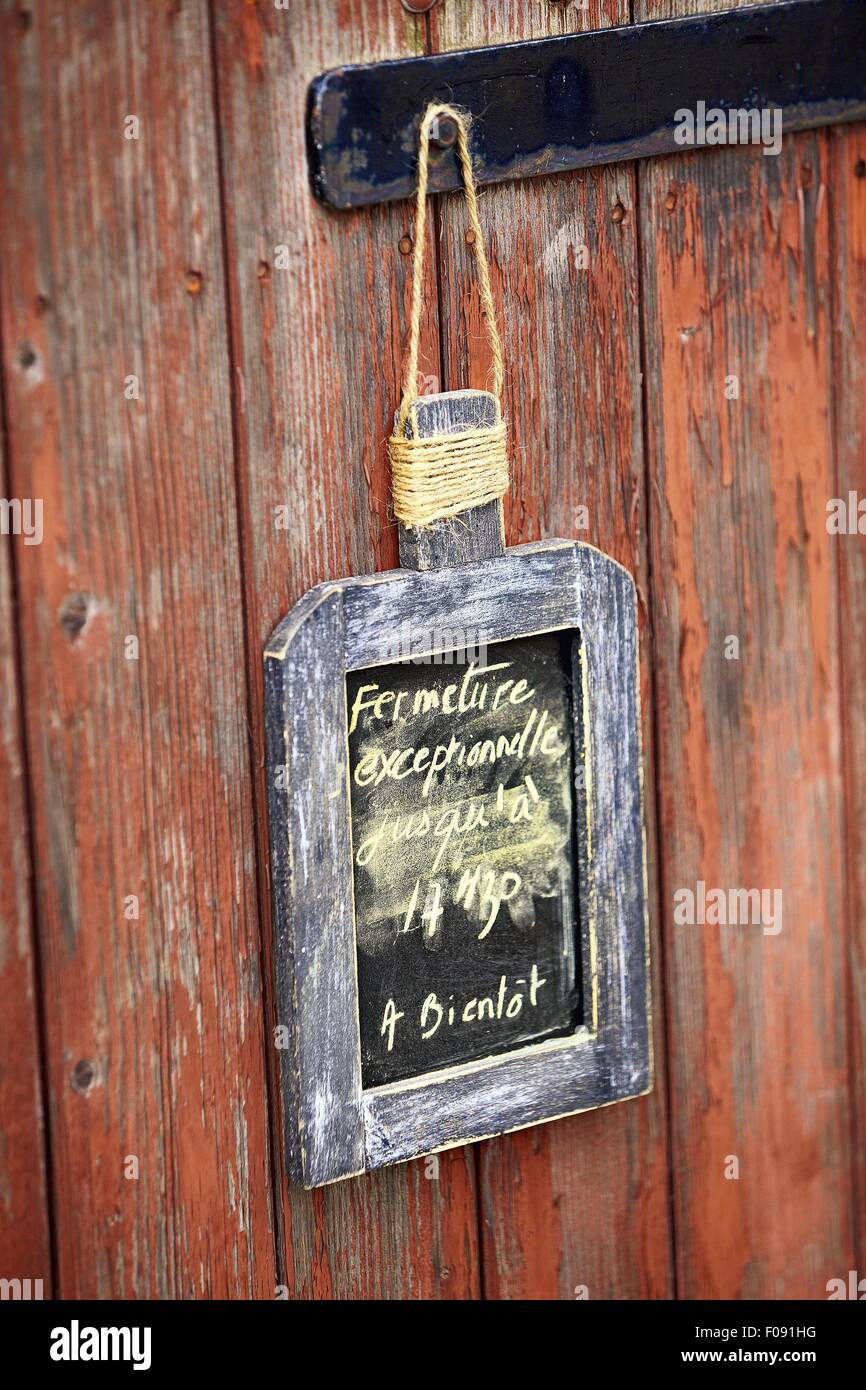 Signboard with opening times on it hanging on wooden wall, France Stock ...