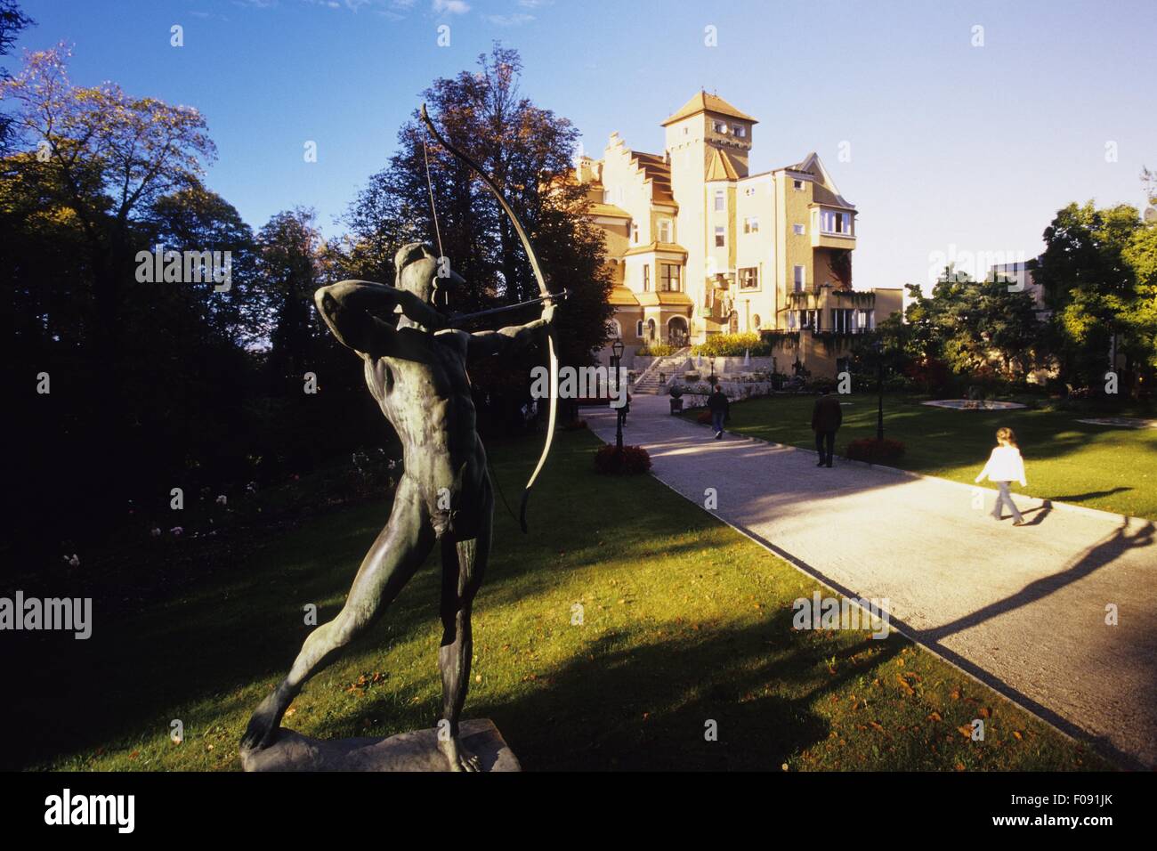 Statue holding bow and arrow near stone castle, Salzburg, Austria Stock ...