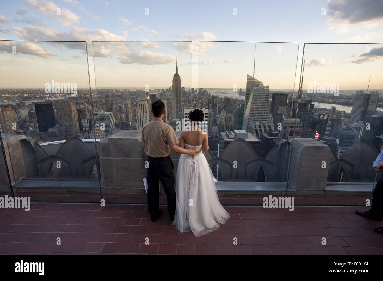 Rear view of wedding couple on terrace looking at New York City, USA ...