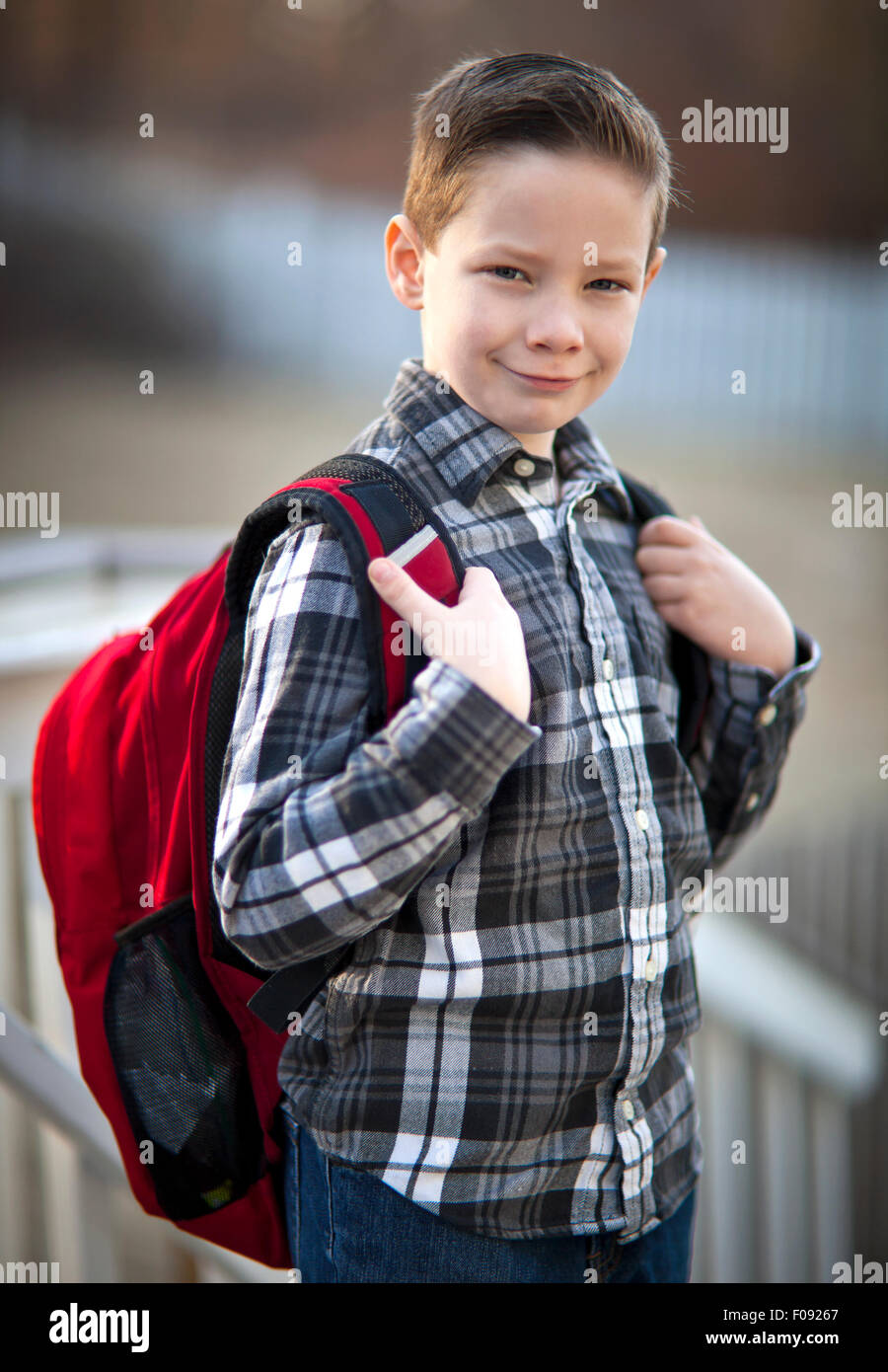 Handsome young boy with a backpack outside Stock Photo - Alamy