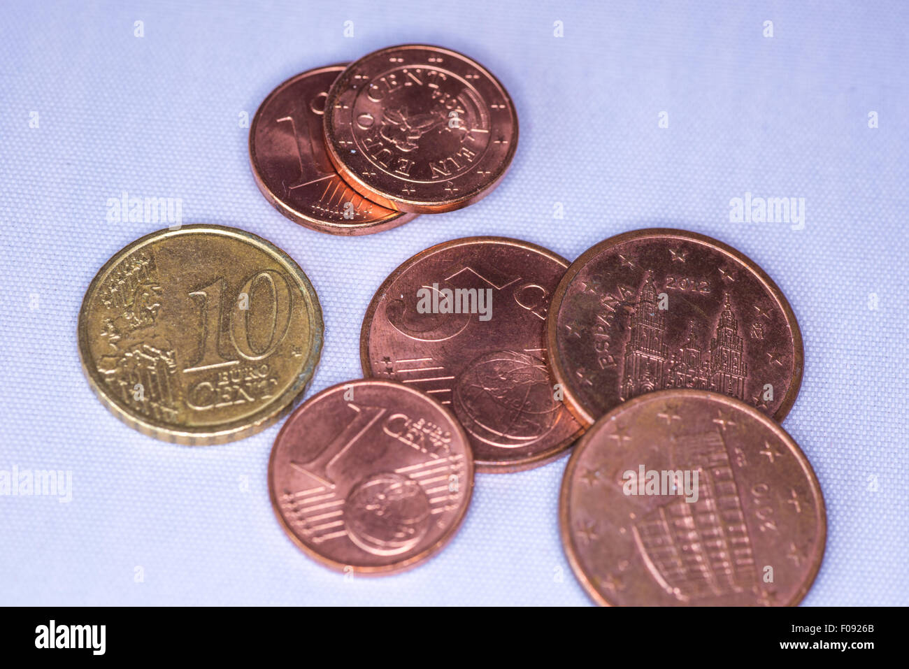 A small pile of Euro small denomination coins on a white background ...