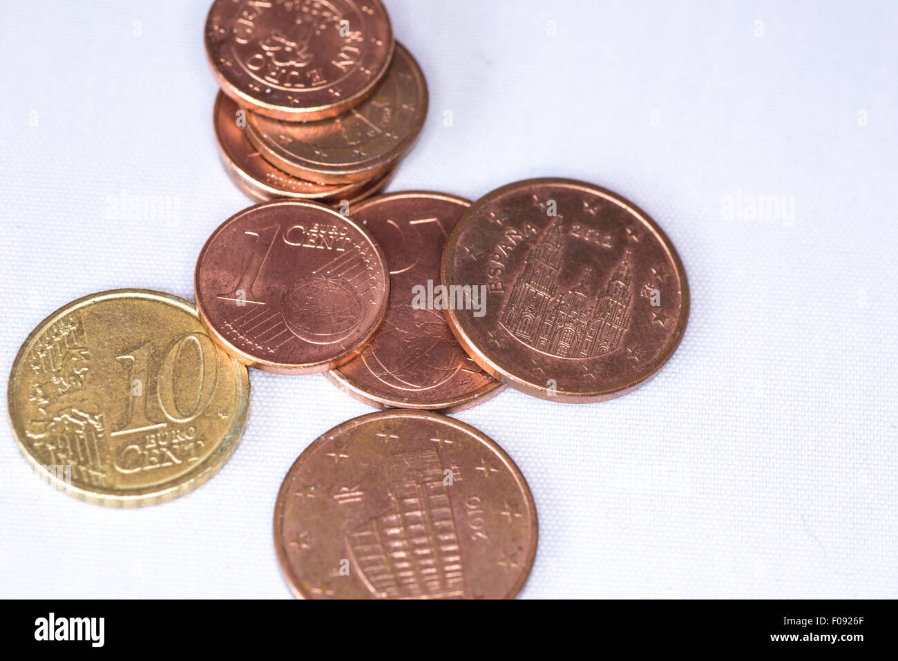 A small pile of Euro small denomination coins on a white background ...