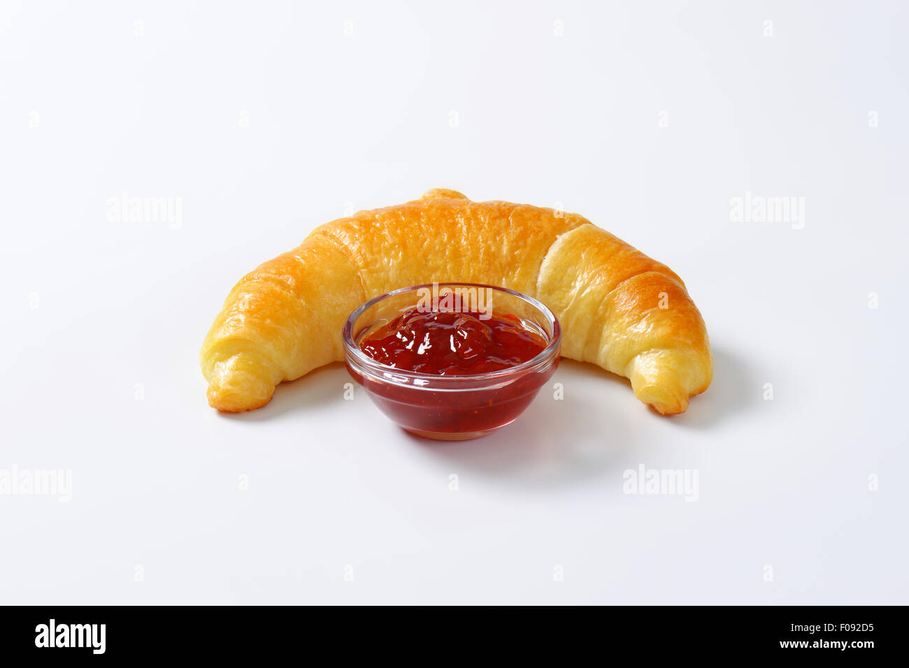 Crisp crescent roll and bowl of jam Stock Photo - Alamy