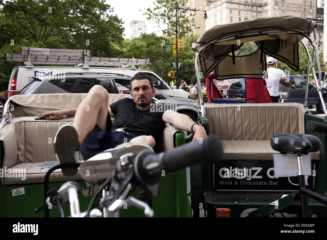 Rickshaw driver relaxing on rickshaw, New York Stock Photo - Alamy