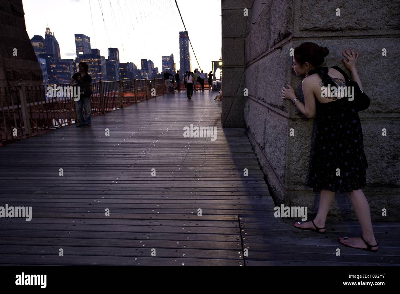 Woman hiding and peeping on Brooklyn Bridge, New York Stock Photo - Alamy