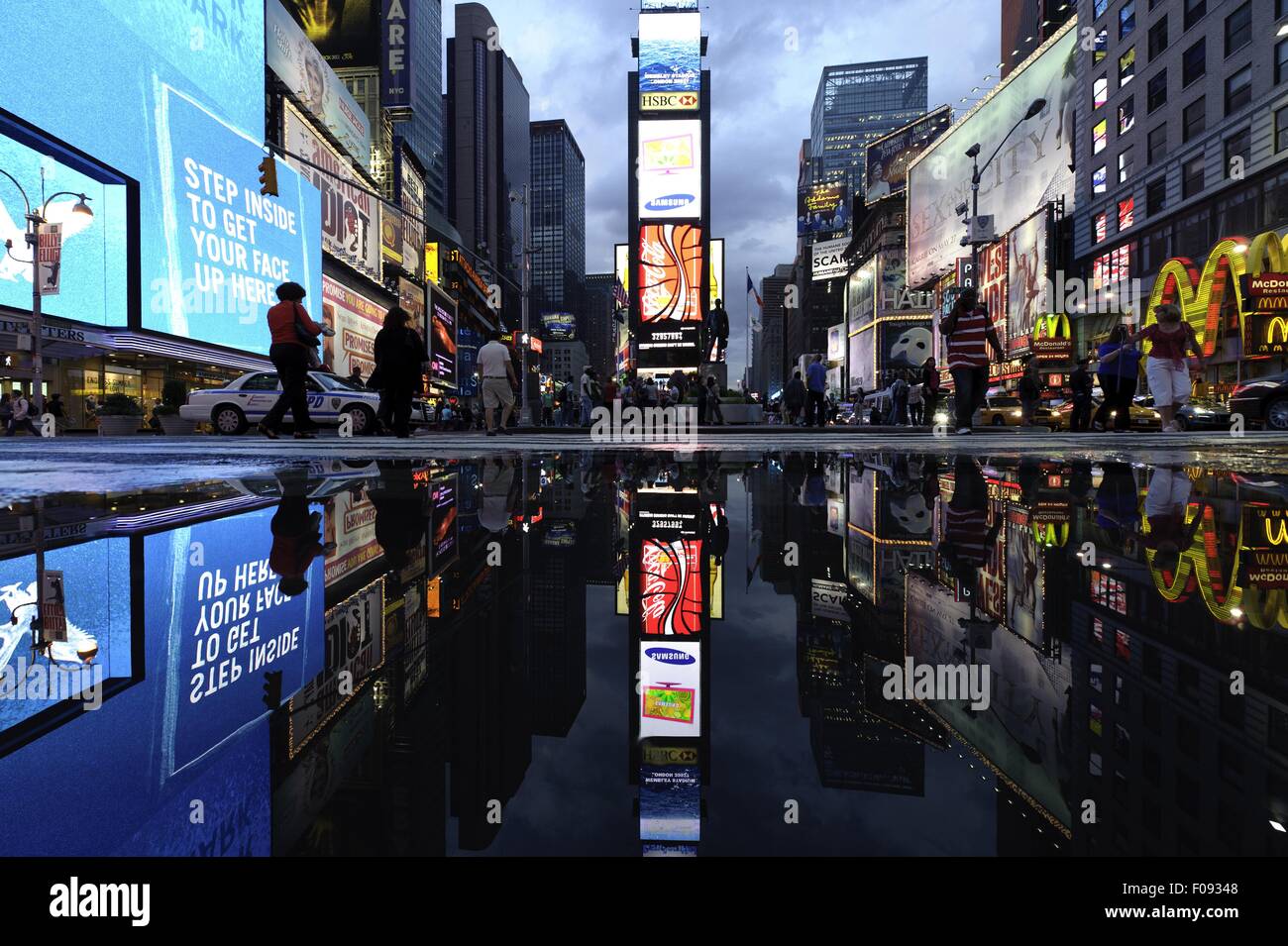 Reflection of illuminated advertisements on puddle at Times Square in ...