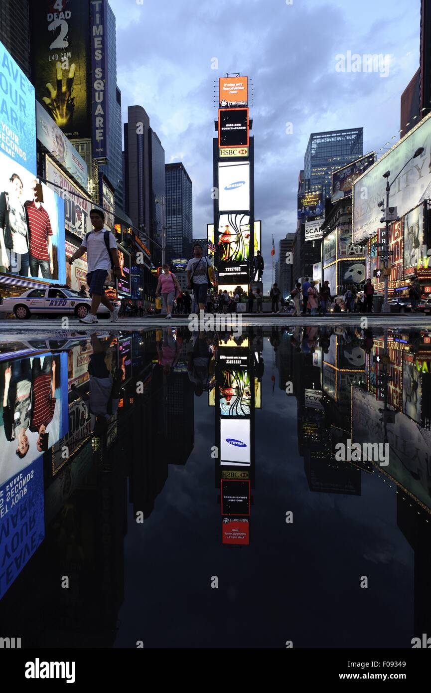 Reflection of illuminated advertisements on puddle at Times Square in ...