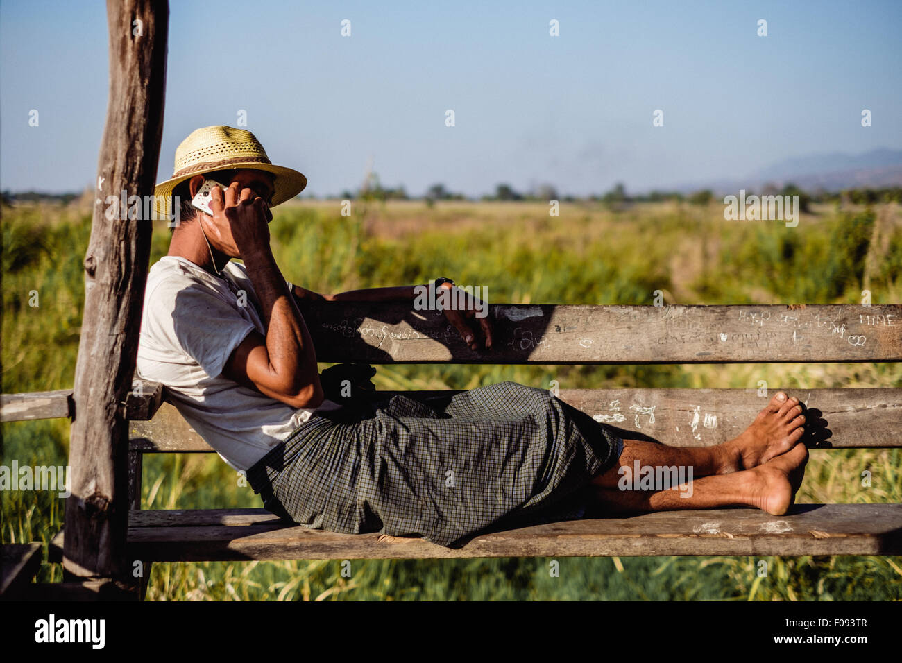 A Burmese man in traditional dress talks on his smartphone Stock Photo ...