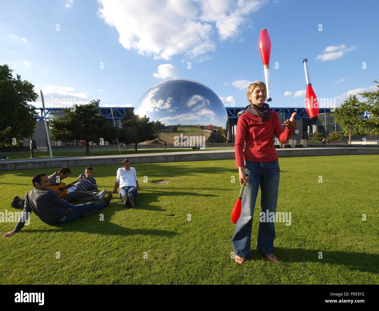 Man standing and juggling in front of IMAX cinema ball at Parc de la ...