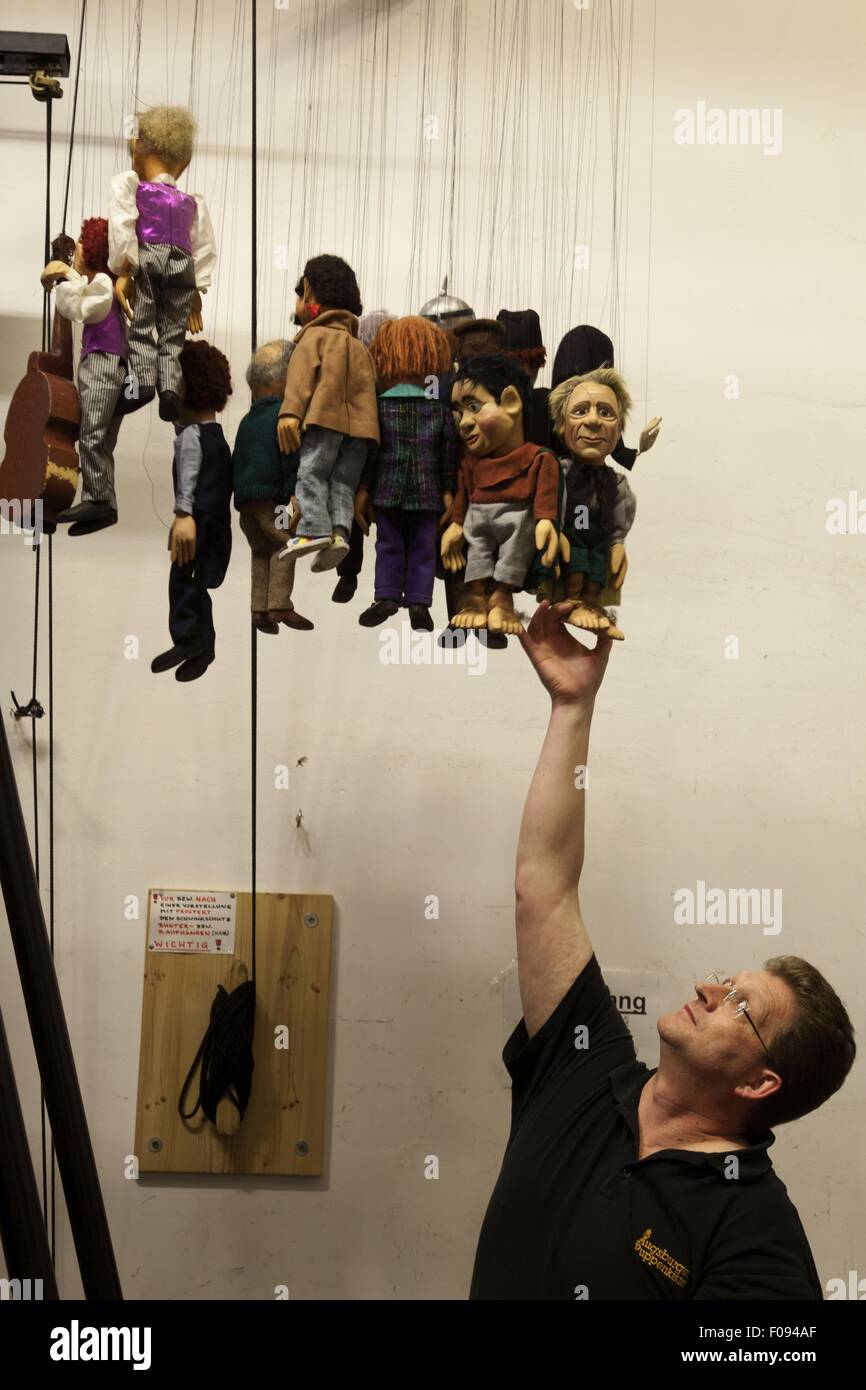 Puppeteer adjusting hanged puppets at Augsburg, Bavaria, Germany Stock ...
