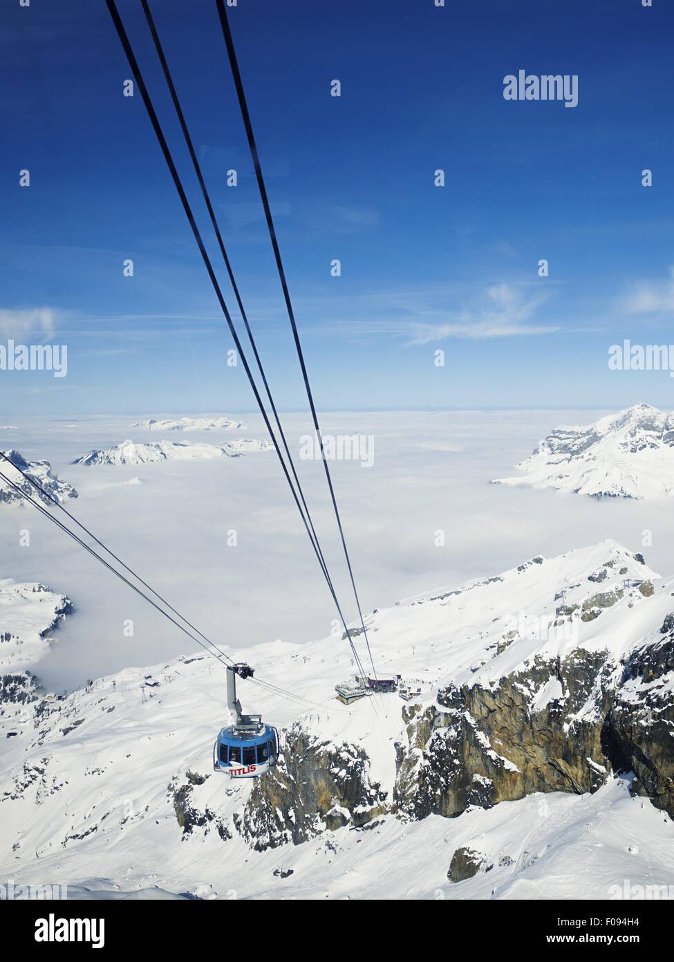 View of Titlis rotating cable car with snow covered mountains, Obwalden ...