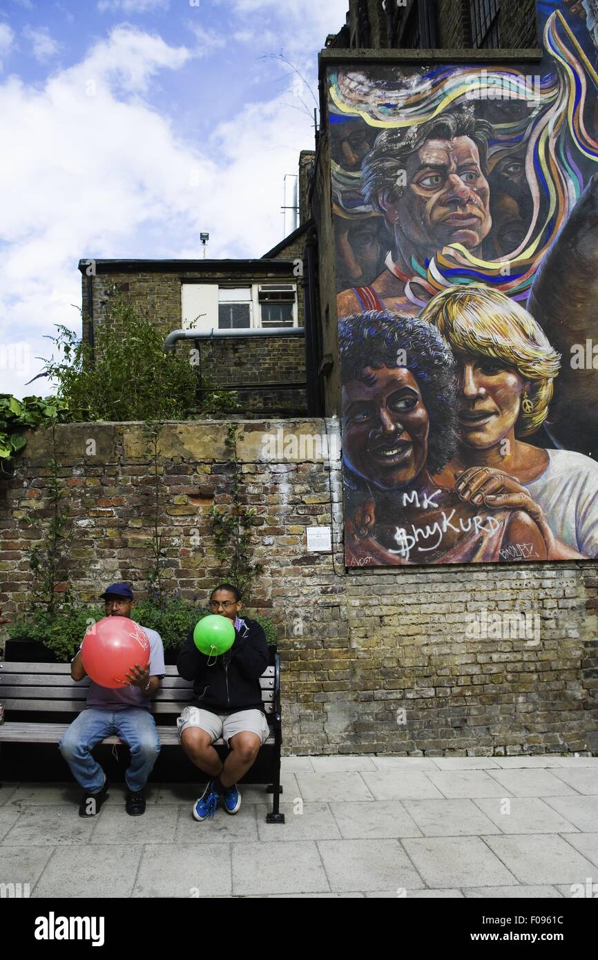 Men blowing balloon at Hackney Peace, Dalston Eastern Curve Garden ...