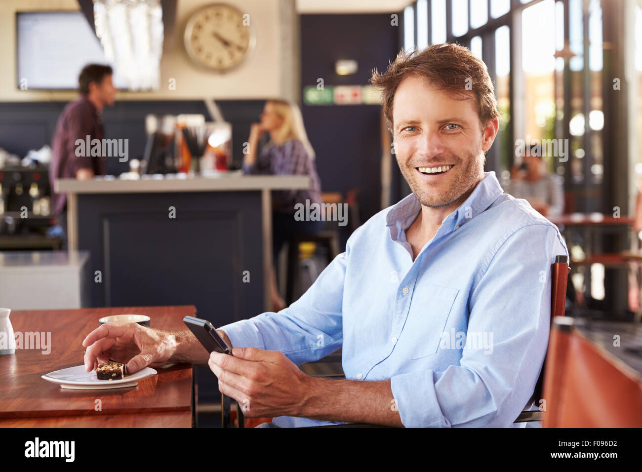Man using smart phone in a coffee shop, portrait Stock Photo - Alamy