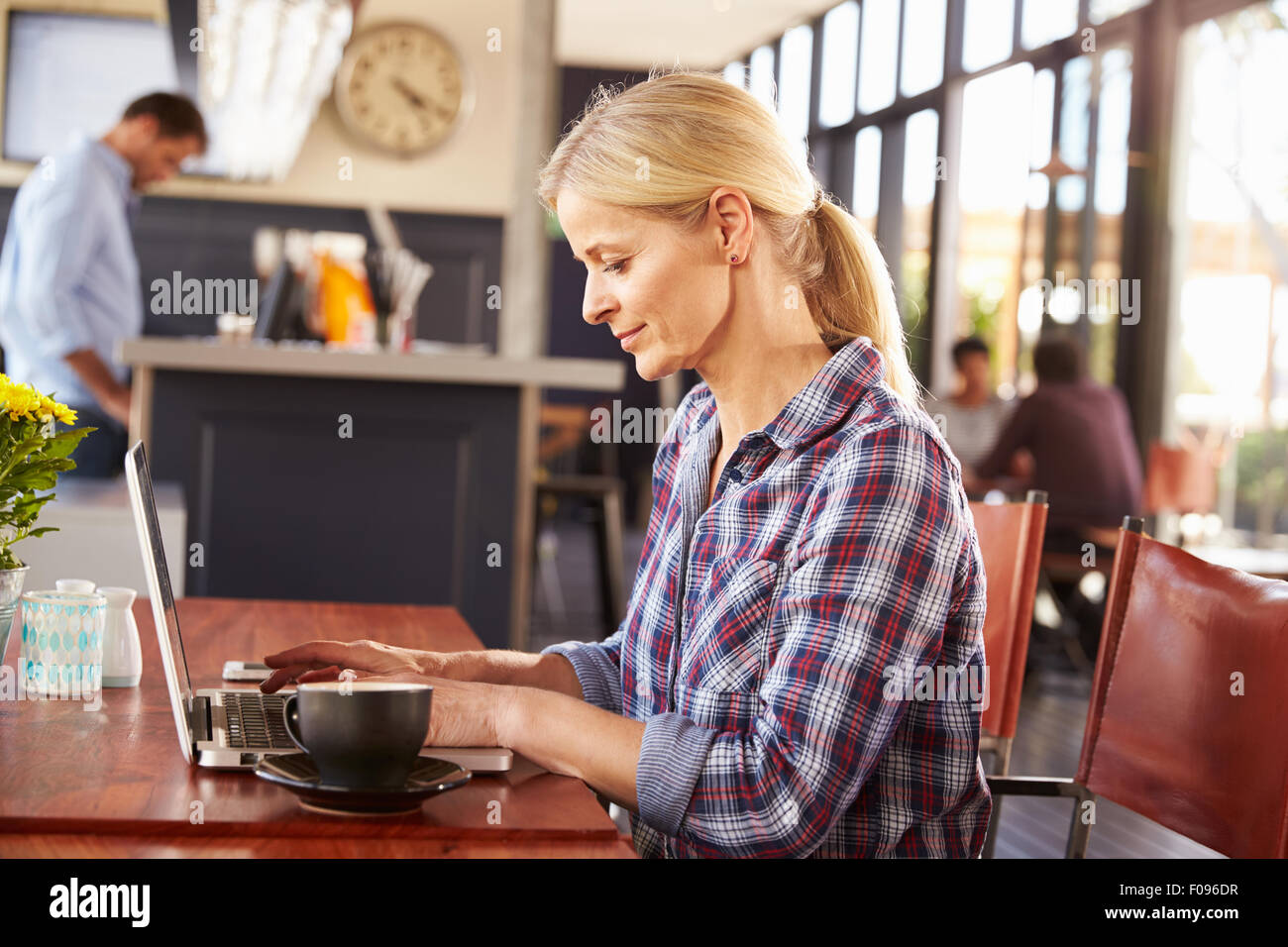 Woman working on laptop computer at a coffee shop Stock Photo - Alamy