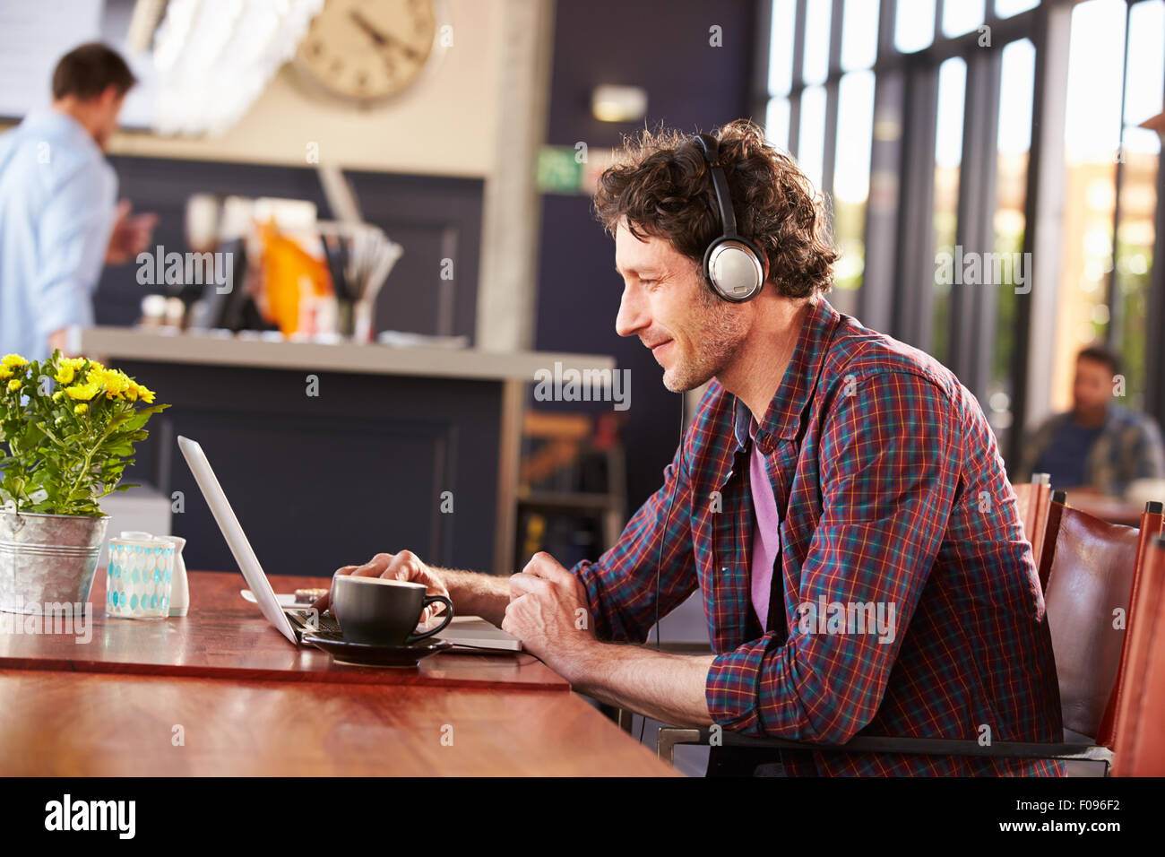 Man working on computer at coffee shop Stock Photo - Alamy