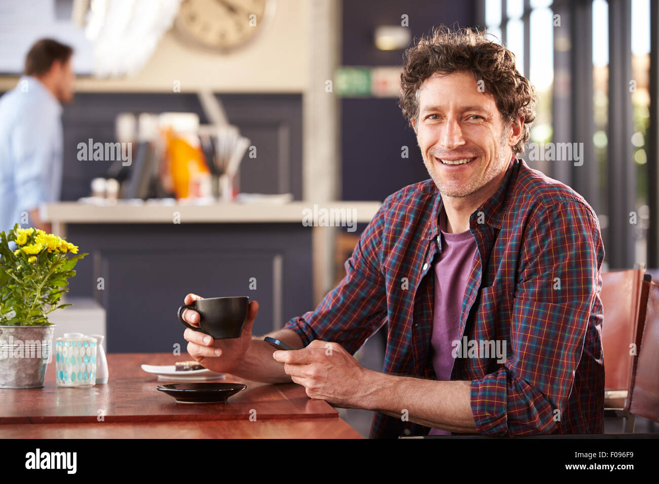 Man at coffee shop using phone, portrait Stock Photo - Alamy