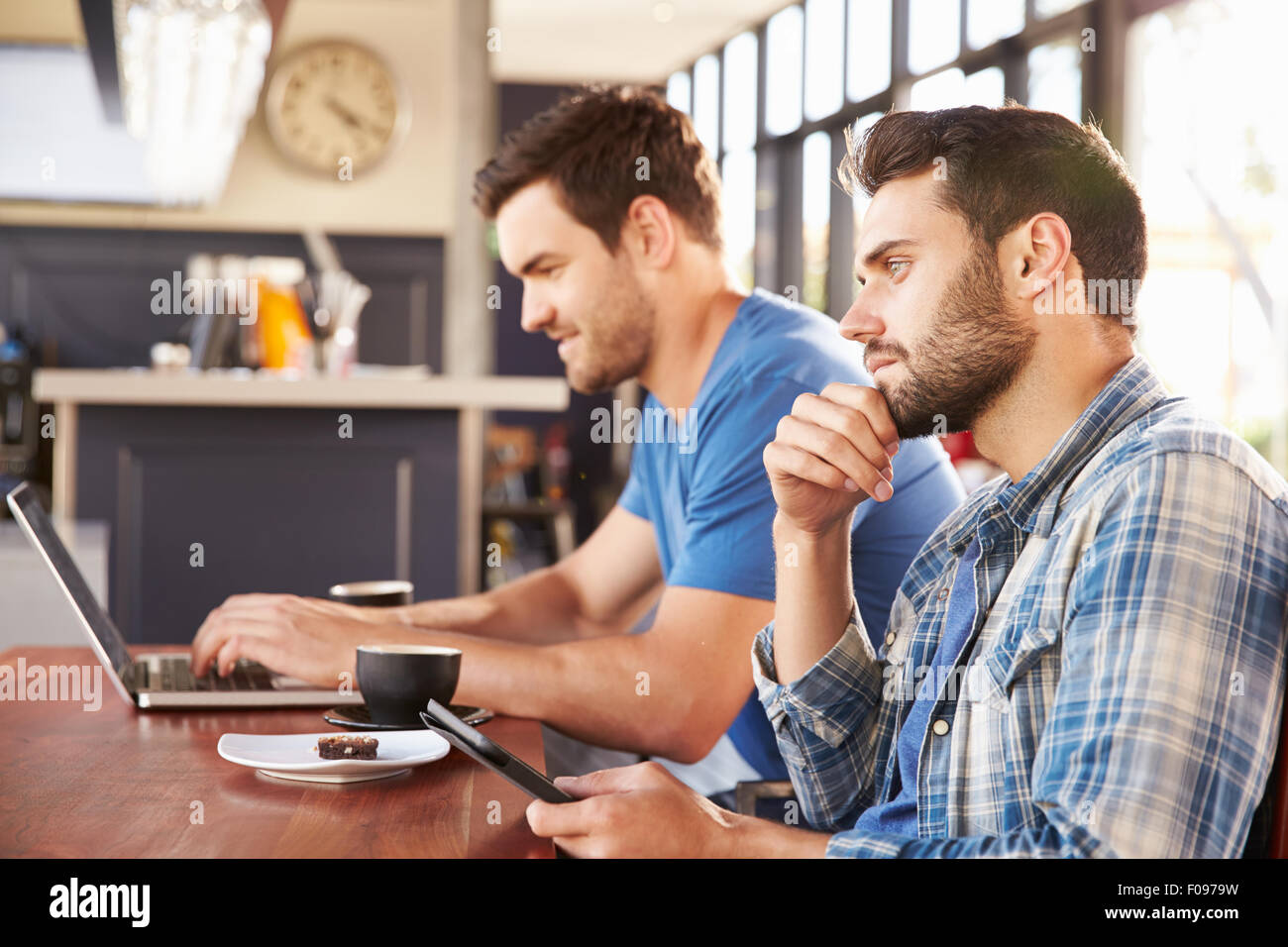 Two young men working on computers at a coffee shop Stock Photo - Alamy