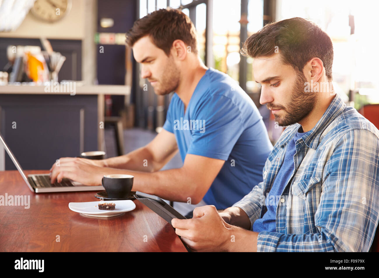 Two young men working on computers at a coffee shop Stock Photo - Alamy