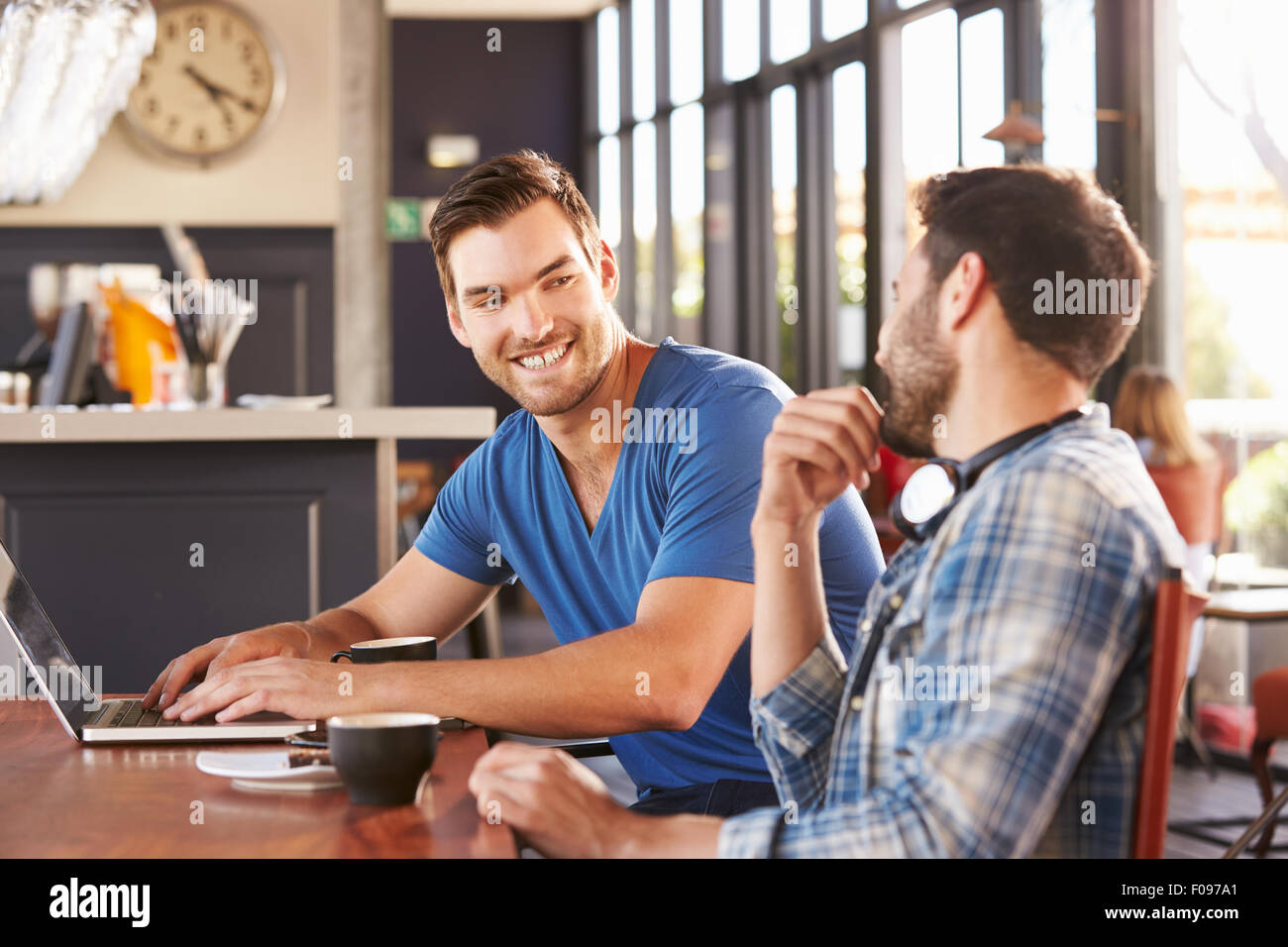 Two young men working on computers at a coffee shop Stock Photo - Alamy