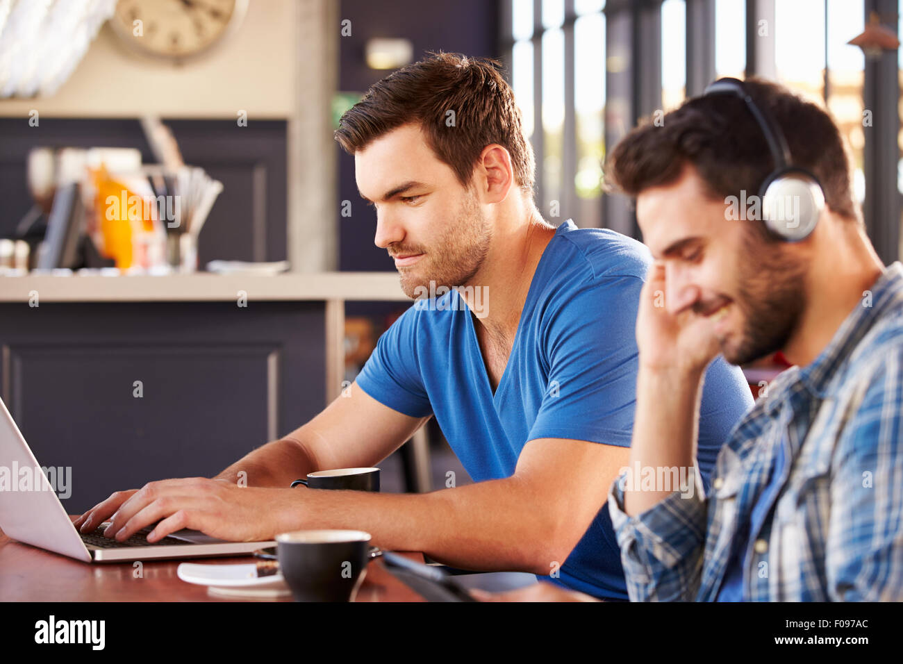 Two young men working on computers at a coffee shop Stock Photo - Alamy