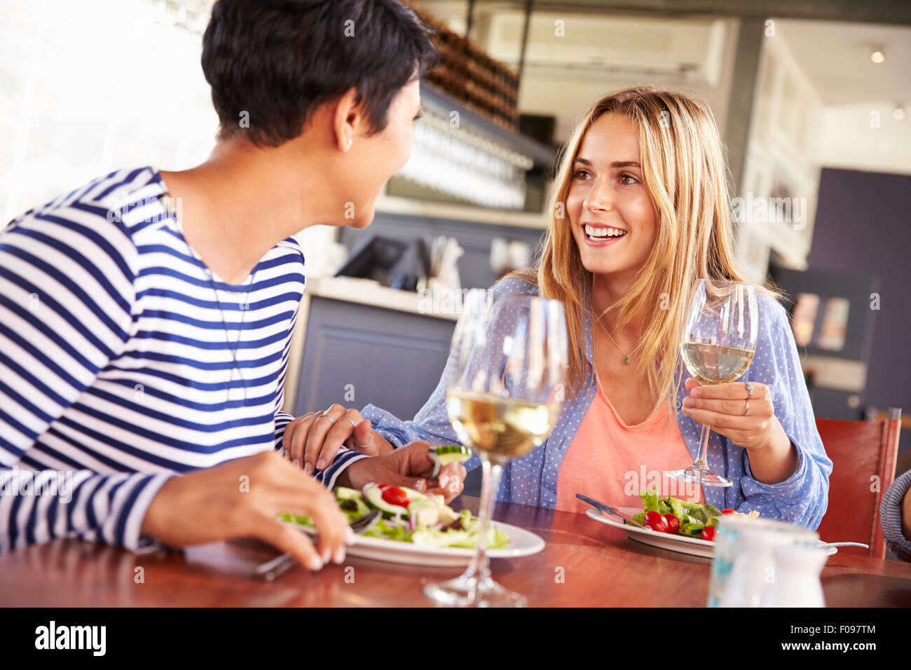 Two female friends eating at a restaurant Stock Photo - Alamy