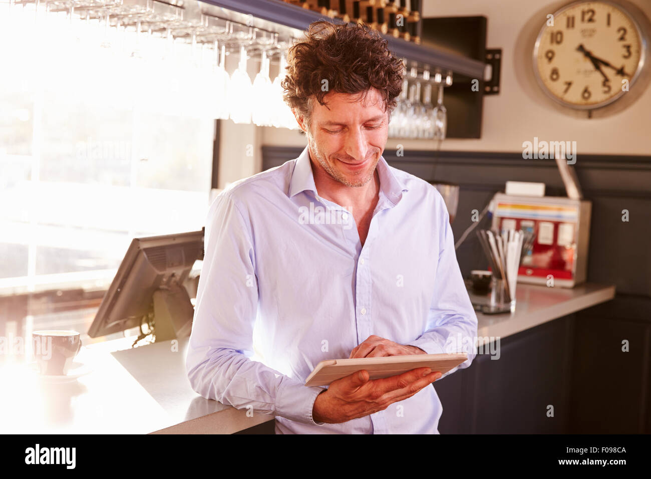 Male restaurant owner owner using digital tablet Stock Photo - Alamy
