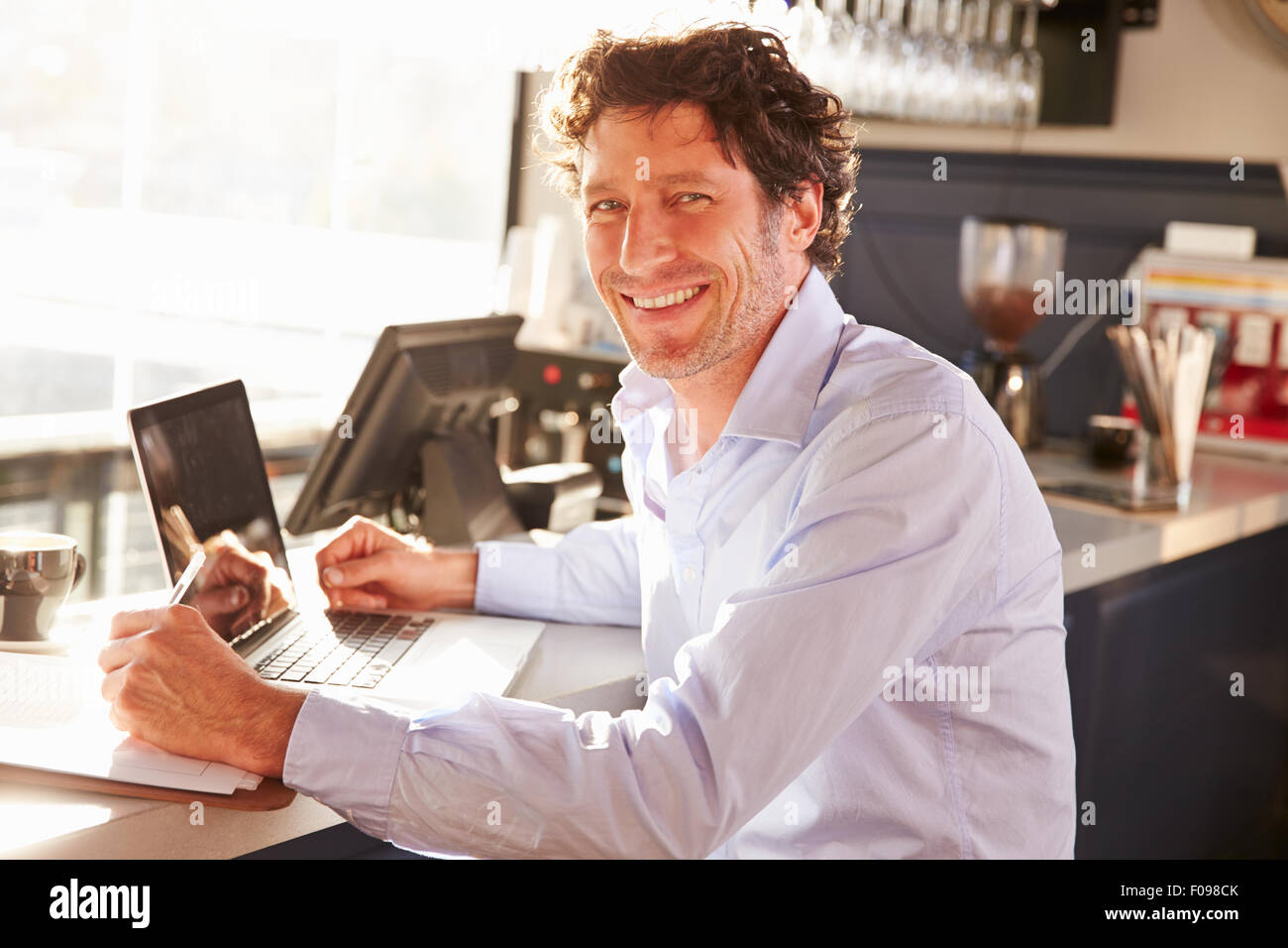 Male restaurant manager working on laptop Stock Photo - Alamy