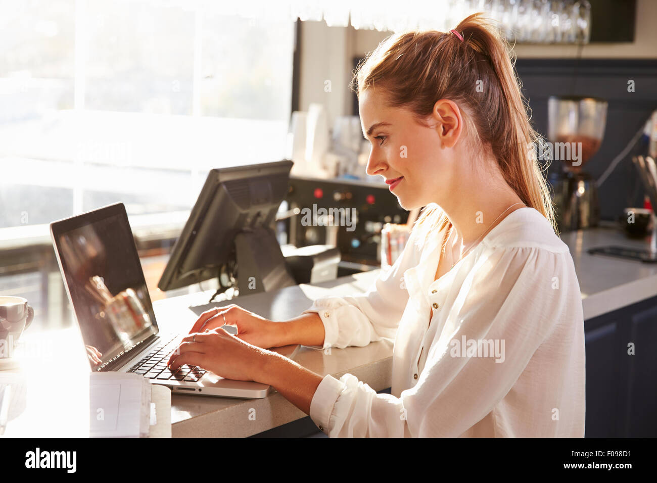 Female restaurant manager working at counter Stock Photo - Alamy