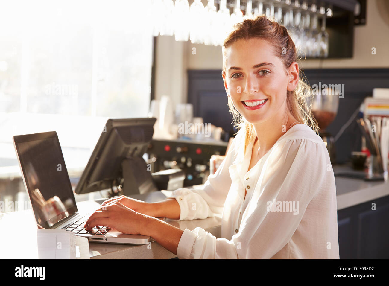 Female restaurant manager working at counter Stock Photo - Alamy