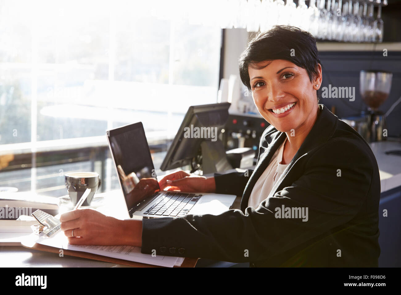 Female restaurant manager working at counter Stock Photo - Alamy