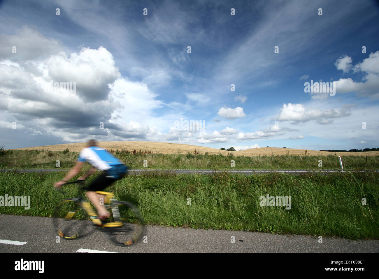 summer sky with nice cloud formation / cyclist passing by Stock Photo ...