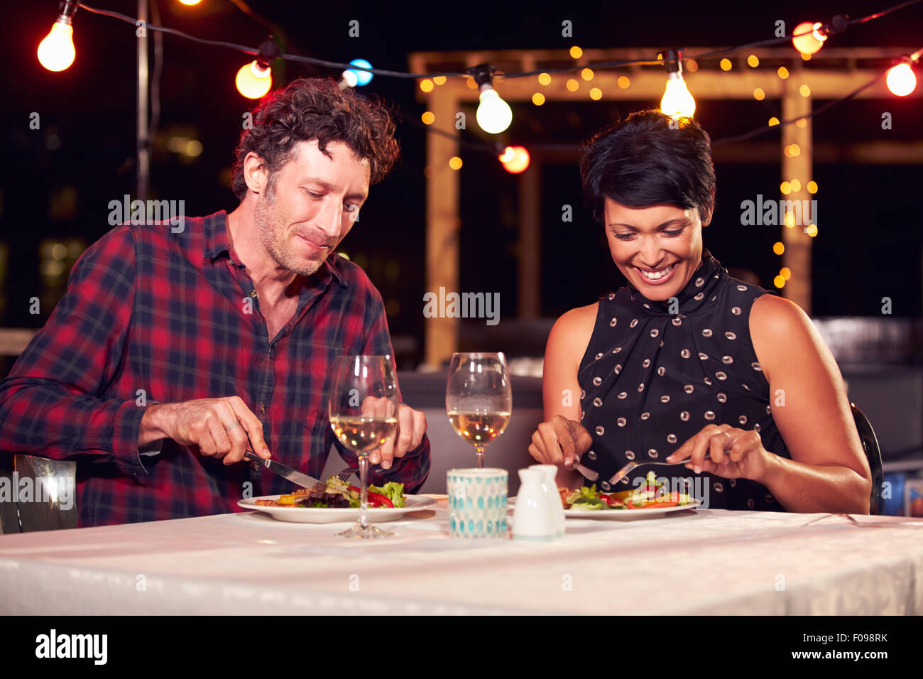 Couple eating dinner at rooftop restuarant Stock Photo - Alamy