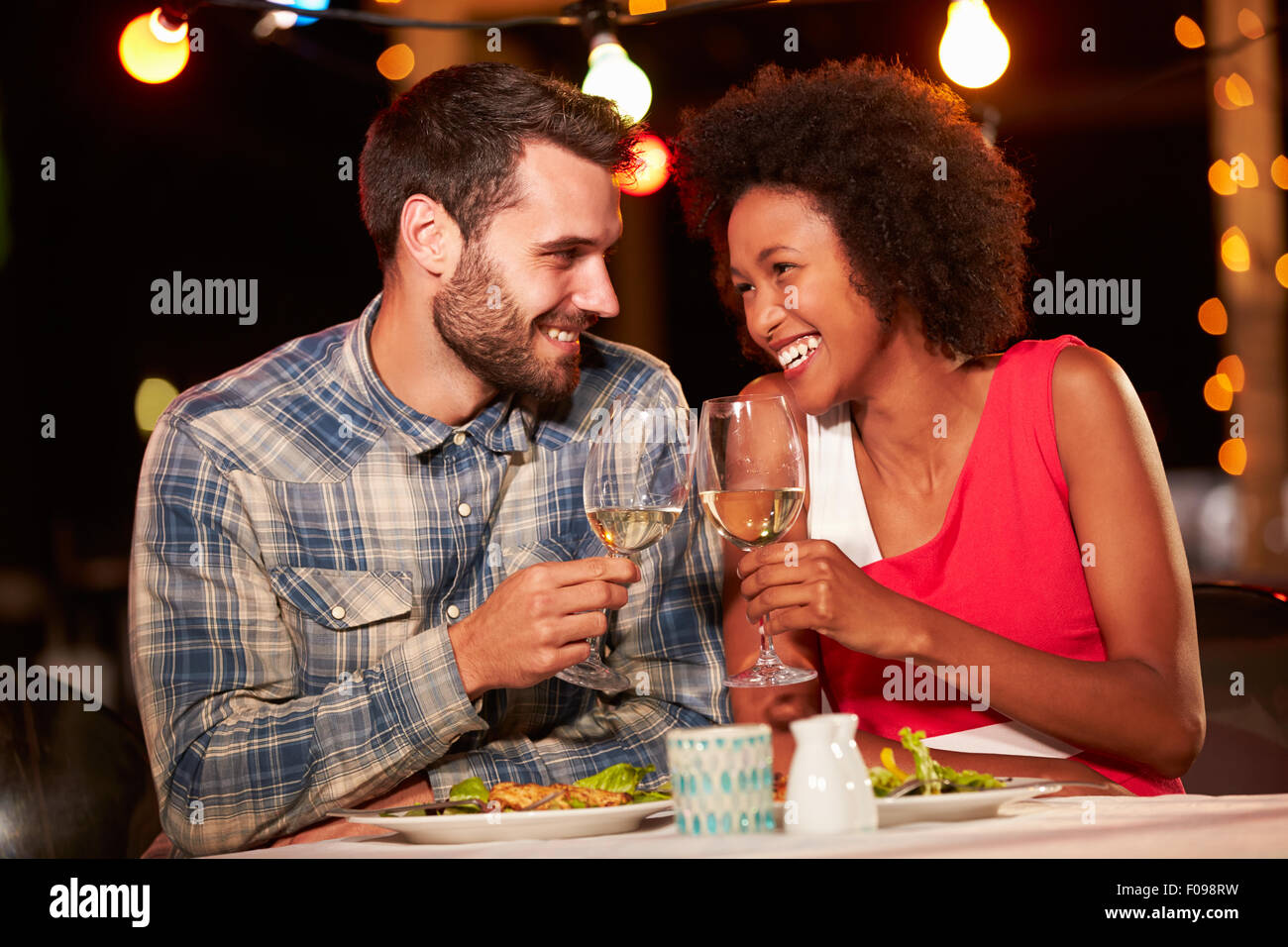 Couple eating dinner at rooftop restuarant Stock Photo - Alamy