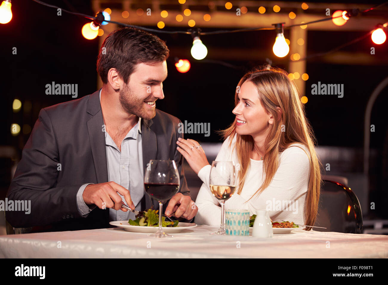 Couple eating dinner at rooftop restuarant Stock Photo - Alamy