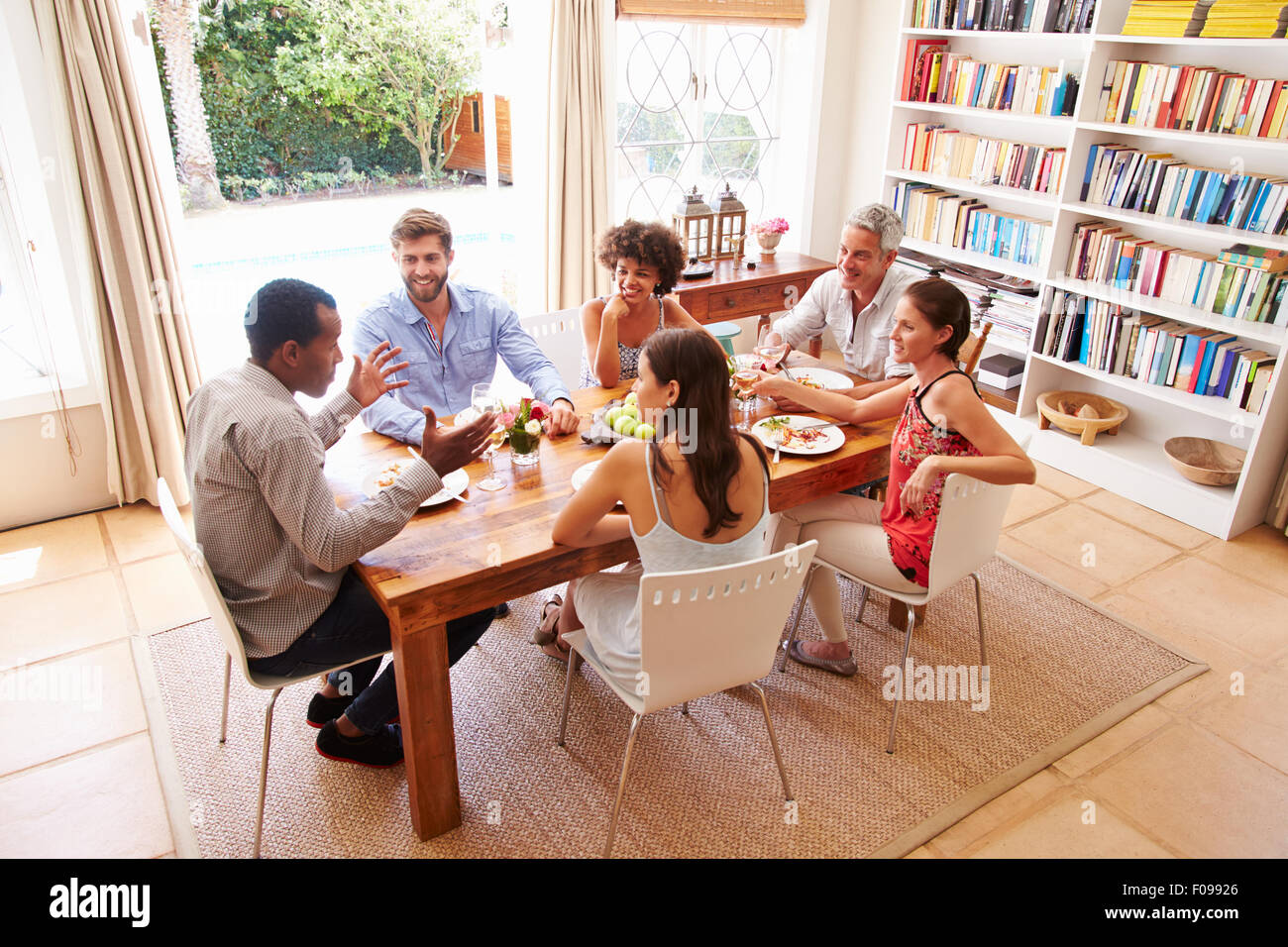 Friends sitting at a table talking during a dinner party Stock Photo ...