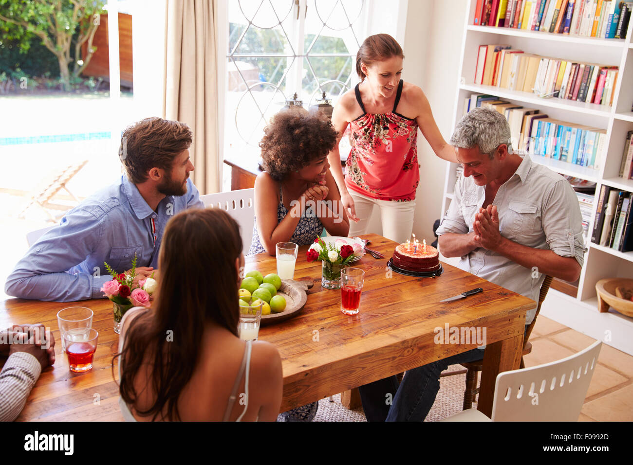 Friends sitting at a dining table celebrating a birthday Stock Photo ...