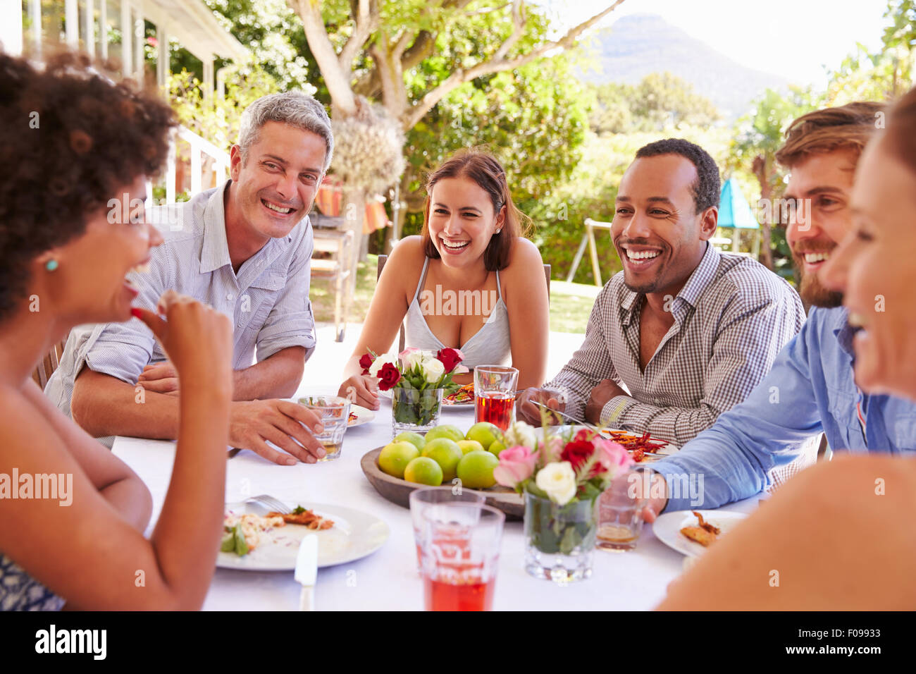 Friends dining together at a table in a garden Stock Photo - Alamy