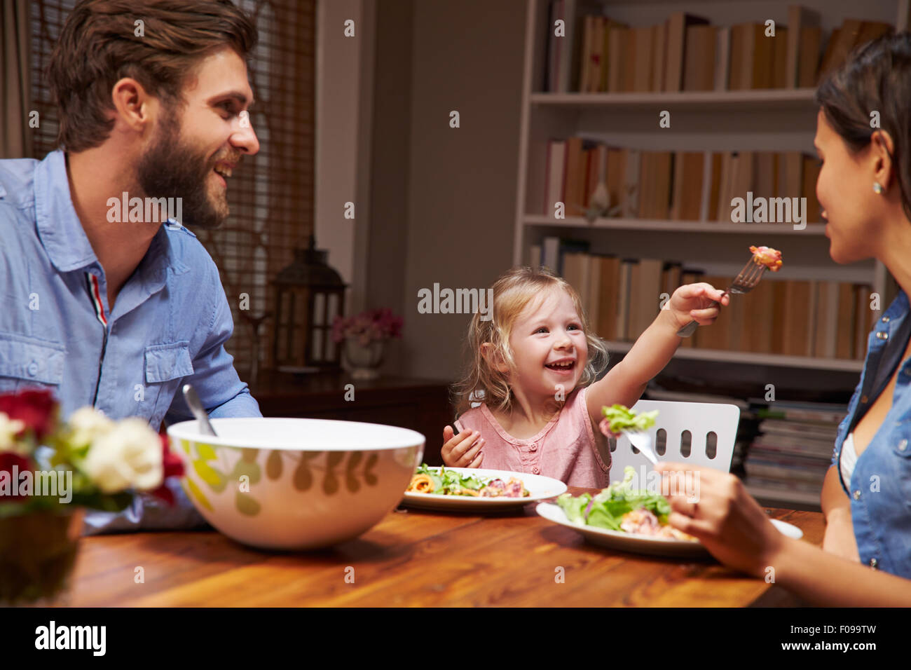 Family eating an dinner at a dining table Stock Photo - Alamy