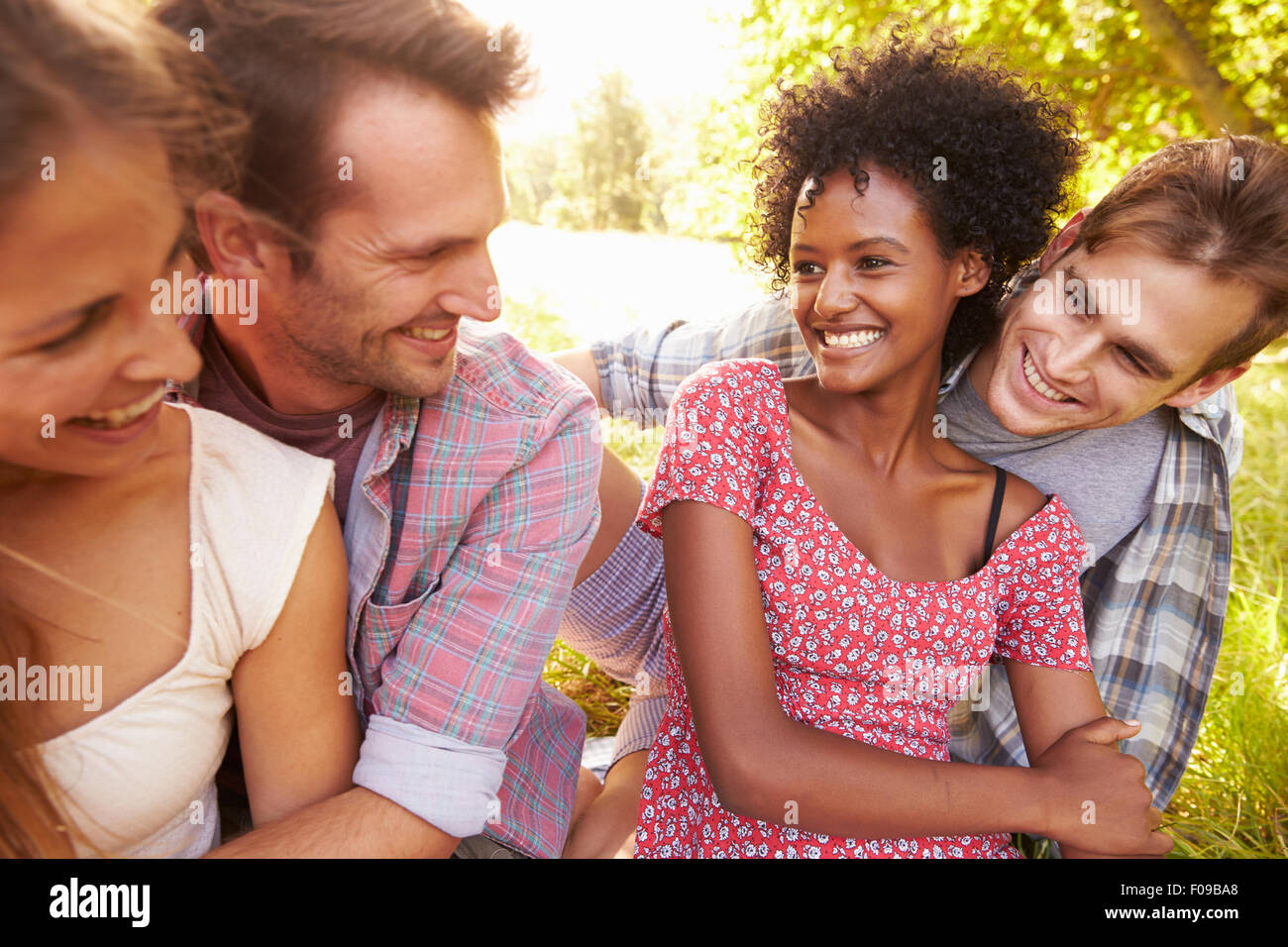 Two couples relaxing together in the countryside Stock Photo - Alamy