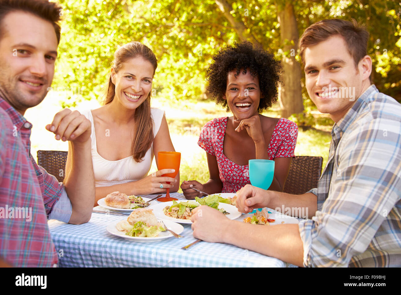 Four friends eating together outdoors Stock Photo - Alamy