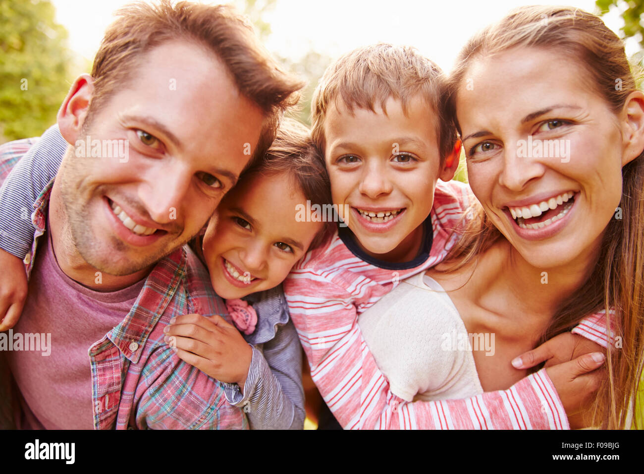 Young kids hugging parents outdoors, close up portrait Stock Photo - Alamy