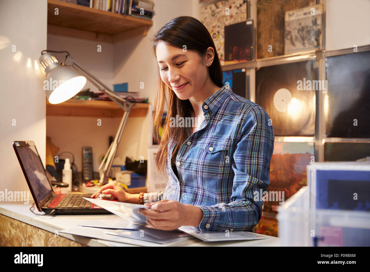 Young woman working behind the counter at a record shop Stock Photo - Alamy