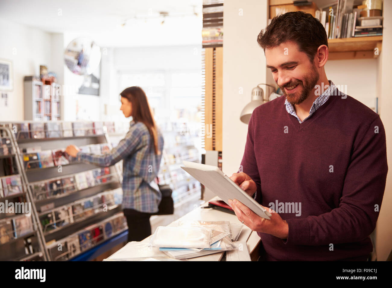 Man using digital tablet behind the counter at a record shop Stock ...