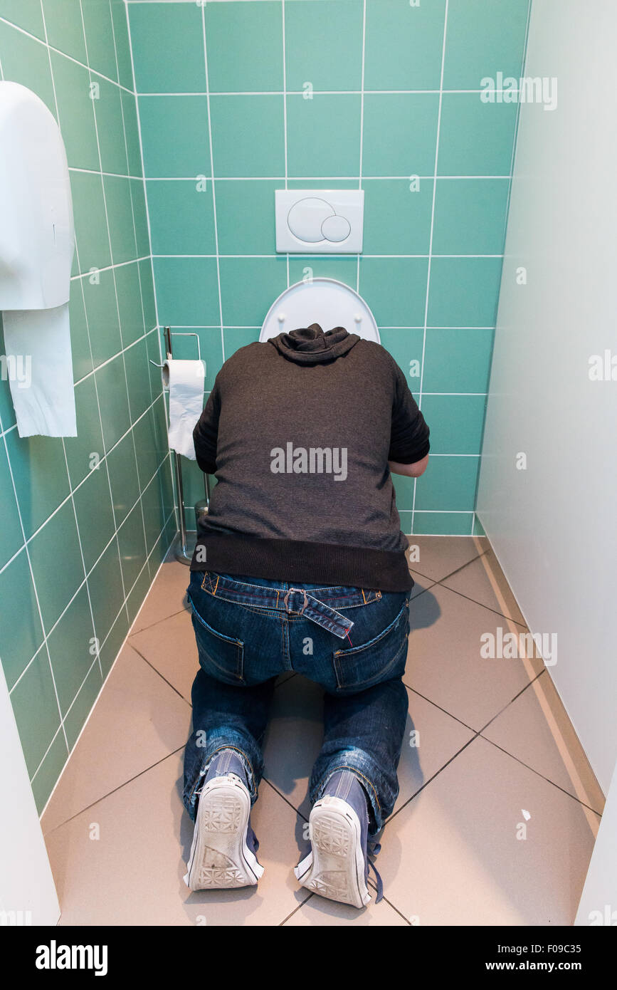 Man kneeling and vomiting in the toilet Stock Photo - Alamy