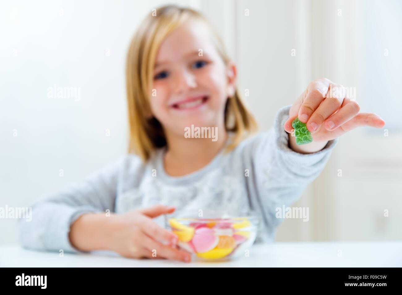 Portrait of beautiful child eating sweets at home Stock Photo - Alamy