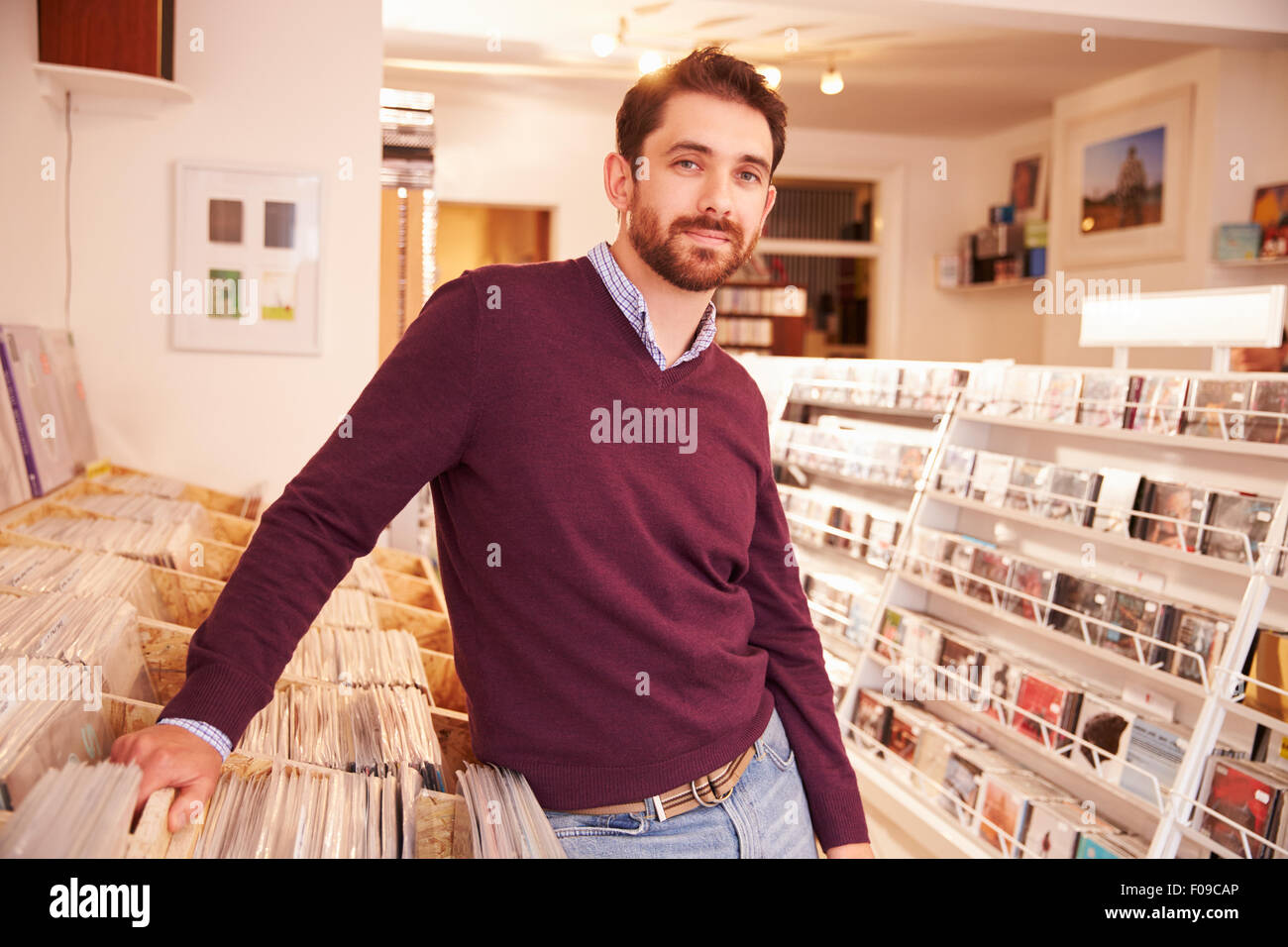 Shop owner posing in a record shop Stock Photo - Alamy